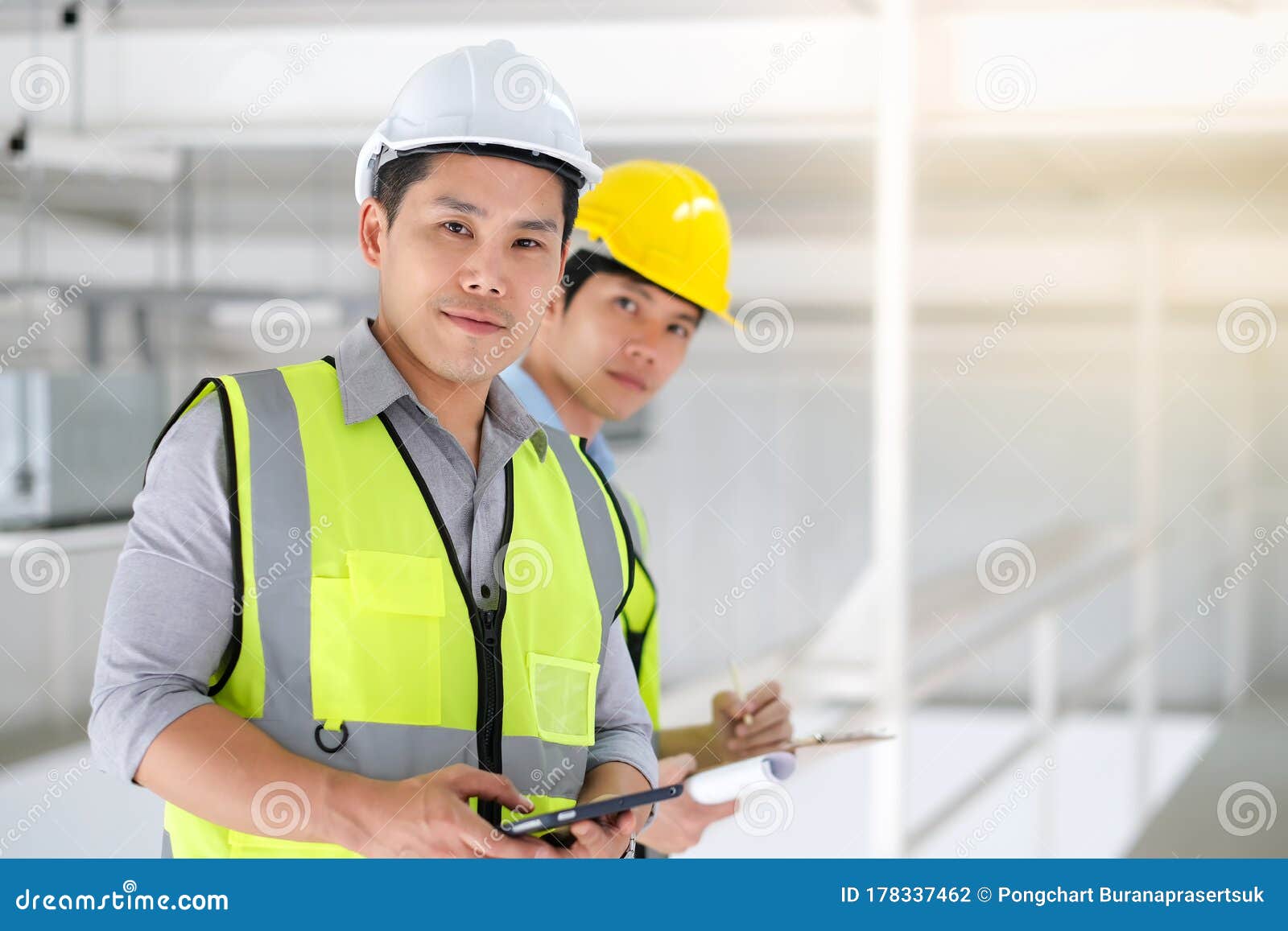 Two Engineers Man Standing in the Site. Engineer Holding Tablet and ...