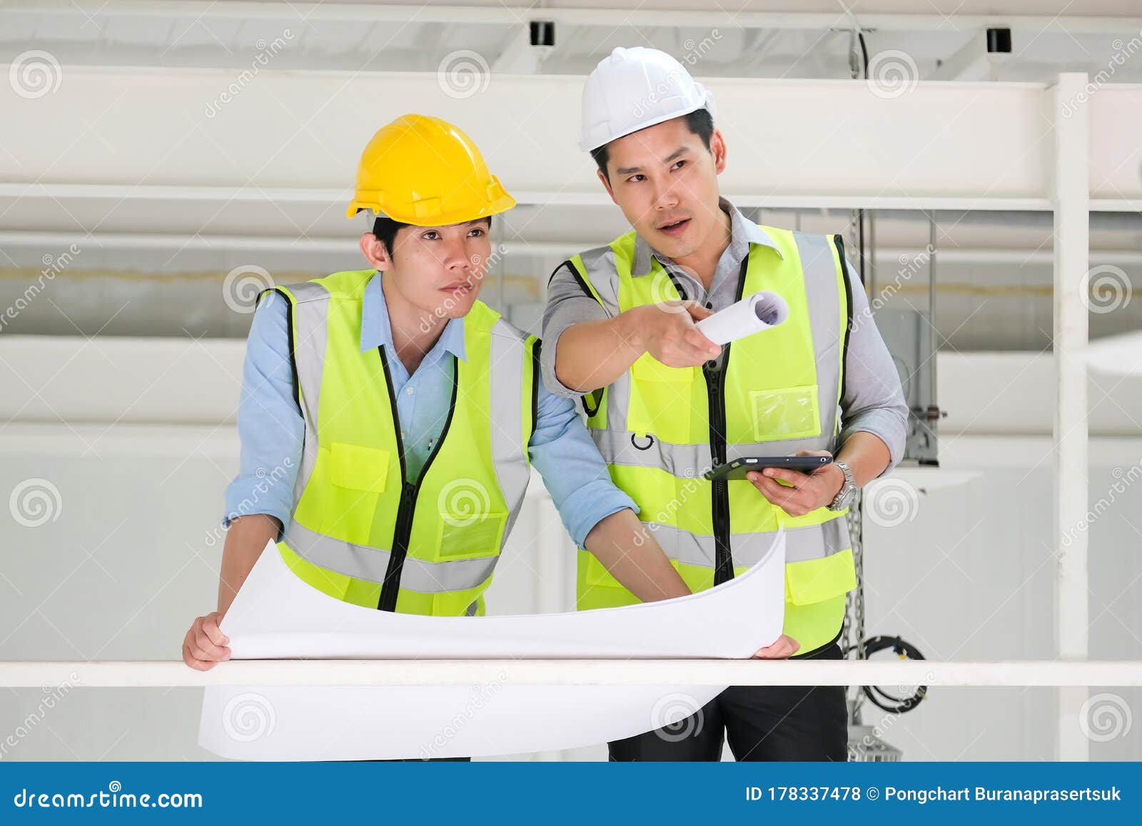Two Engineers Man Standing in the Construction Plant. Right Engineer ...