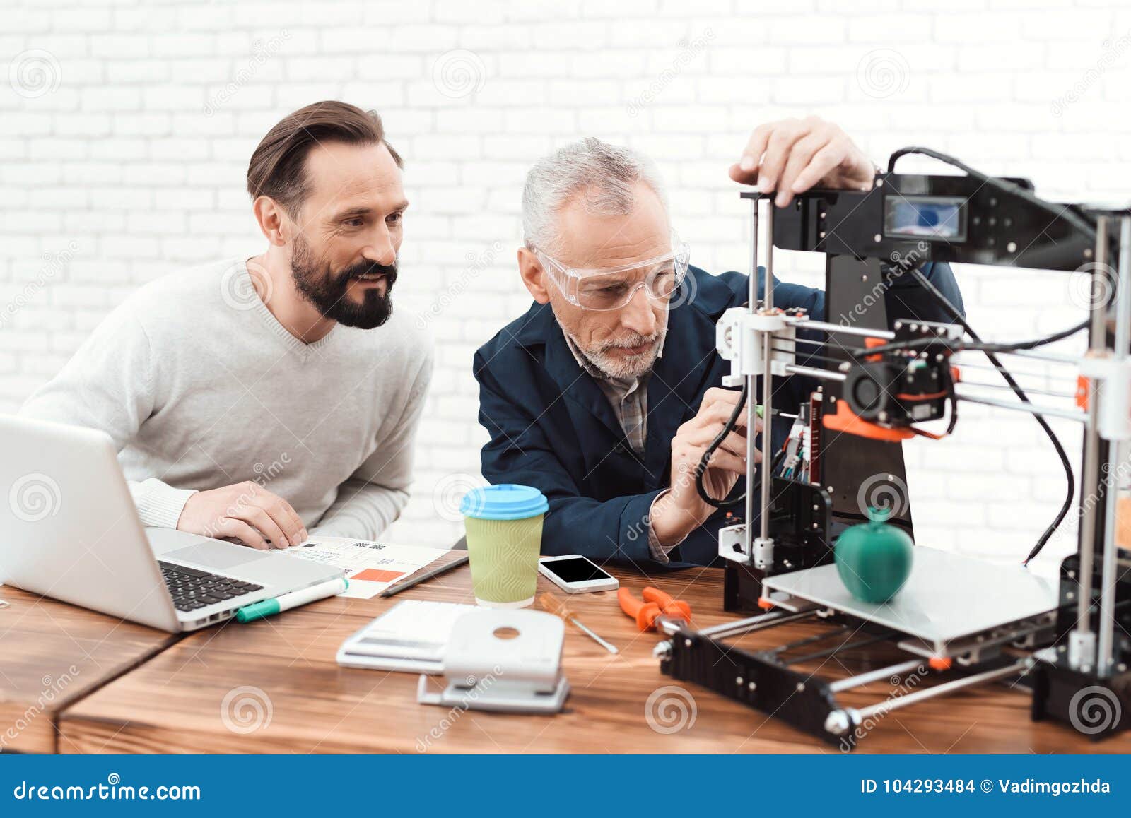 Two Engineers Print The Details On The 3d Printer. An Elderly Man ...