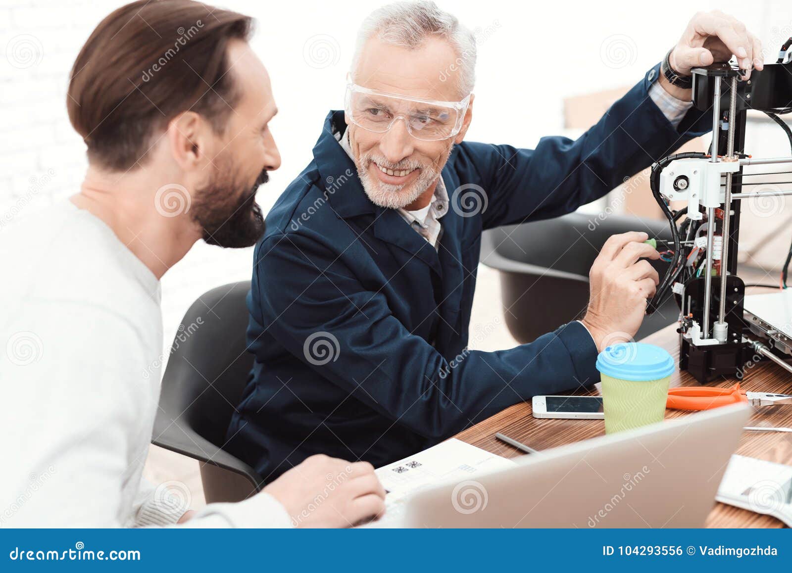 Two Engineers Print The Details On The 3d Printer. An Elderly Man ...