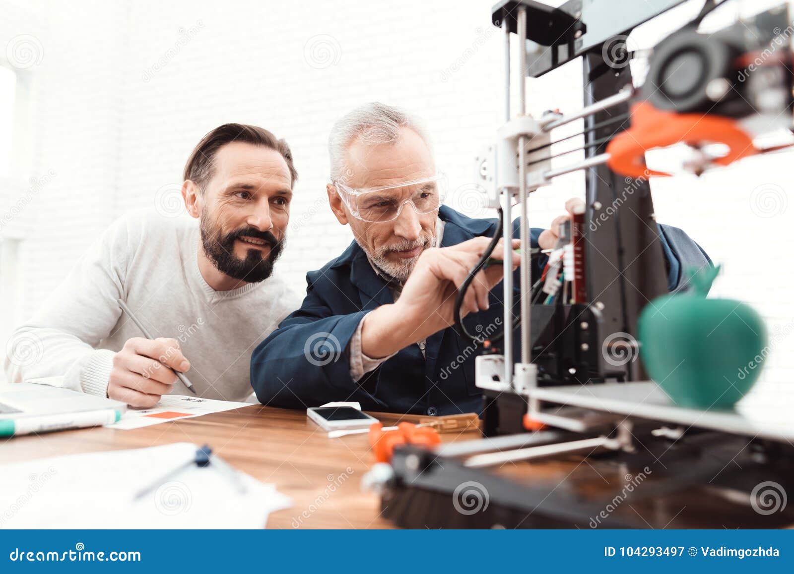 Two Engineers Print the Details on the 3d Printer. an Elderly Man ...