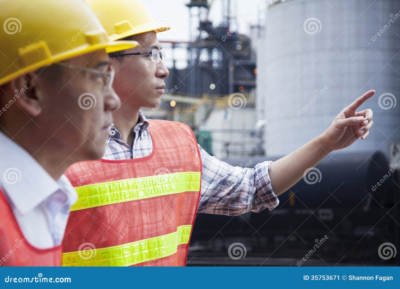 Two Engineers in Protective Workwear Pointing Outside of a Factory ...