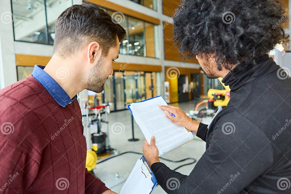 Engineers Discussing Robotics And Automation Solutions In A Modern Office Setting Stock Image