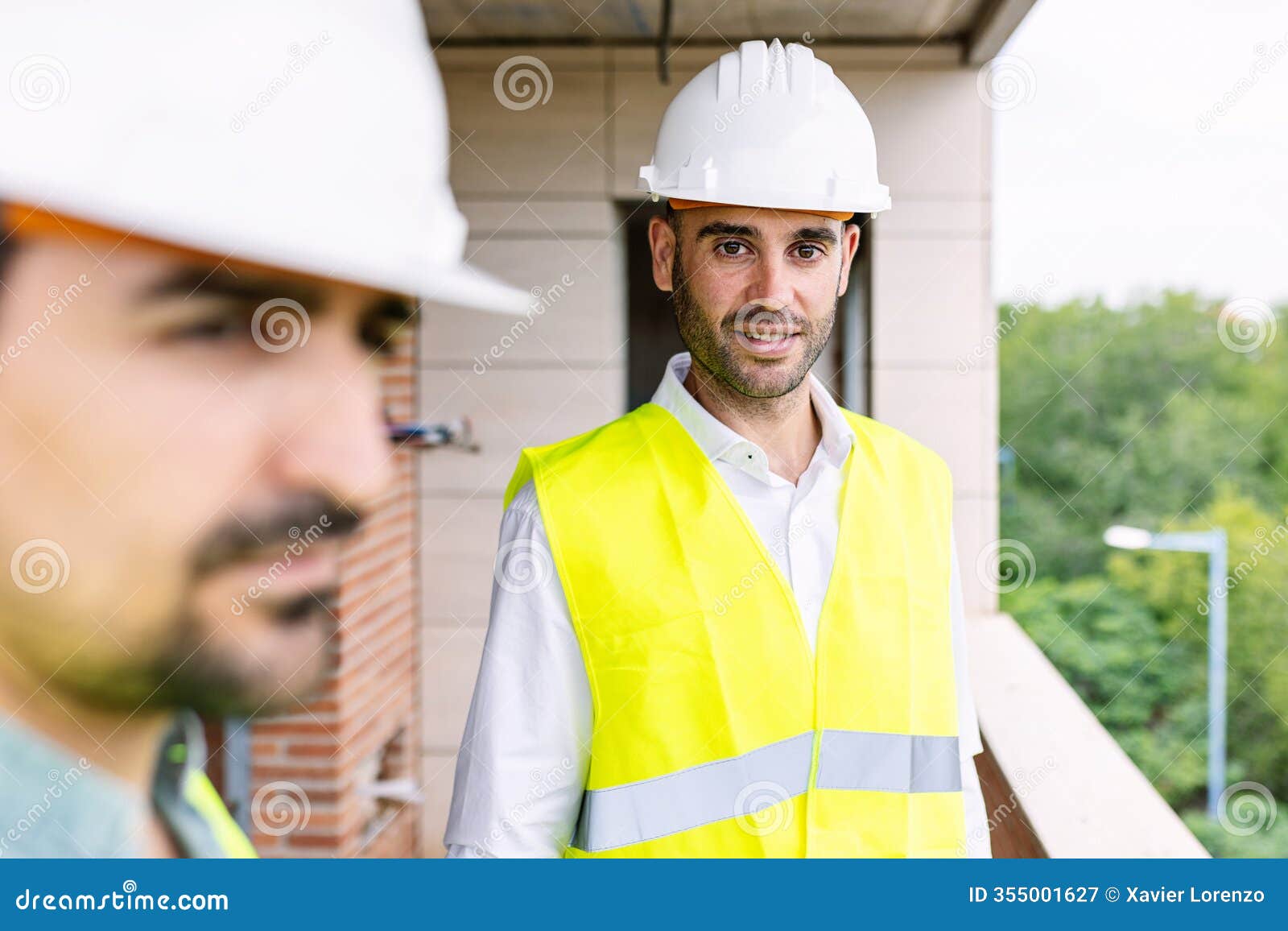 Engineers Wearing Safety Vests and Hardhats Working at Construction ...