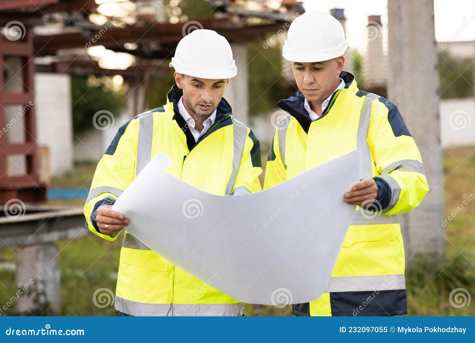 Two Engineers are Talking in Front of Electrical Transmission Lines ...
