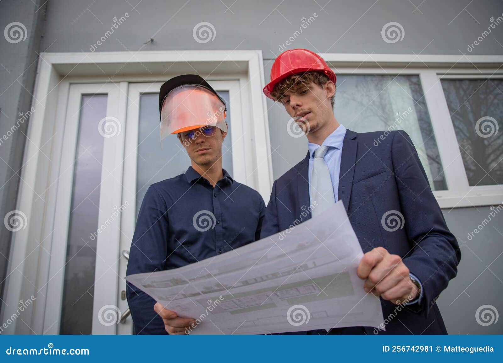 Two Engineers at Work Look at the Floor Plan To Set Up the Work To Be ...