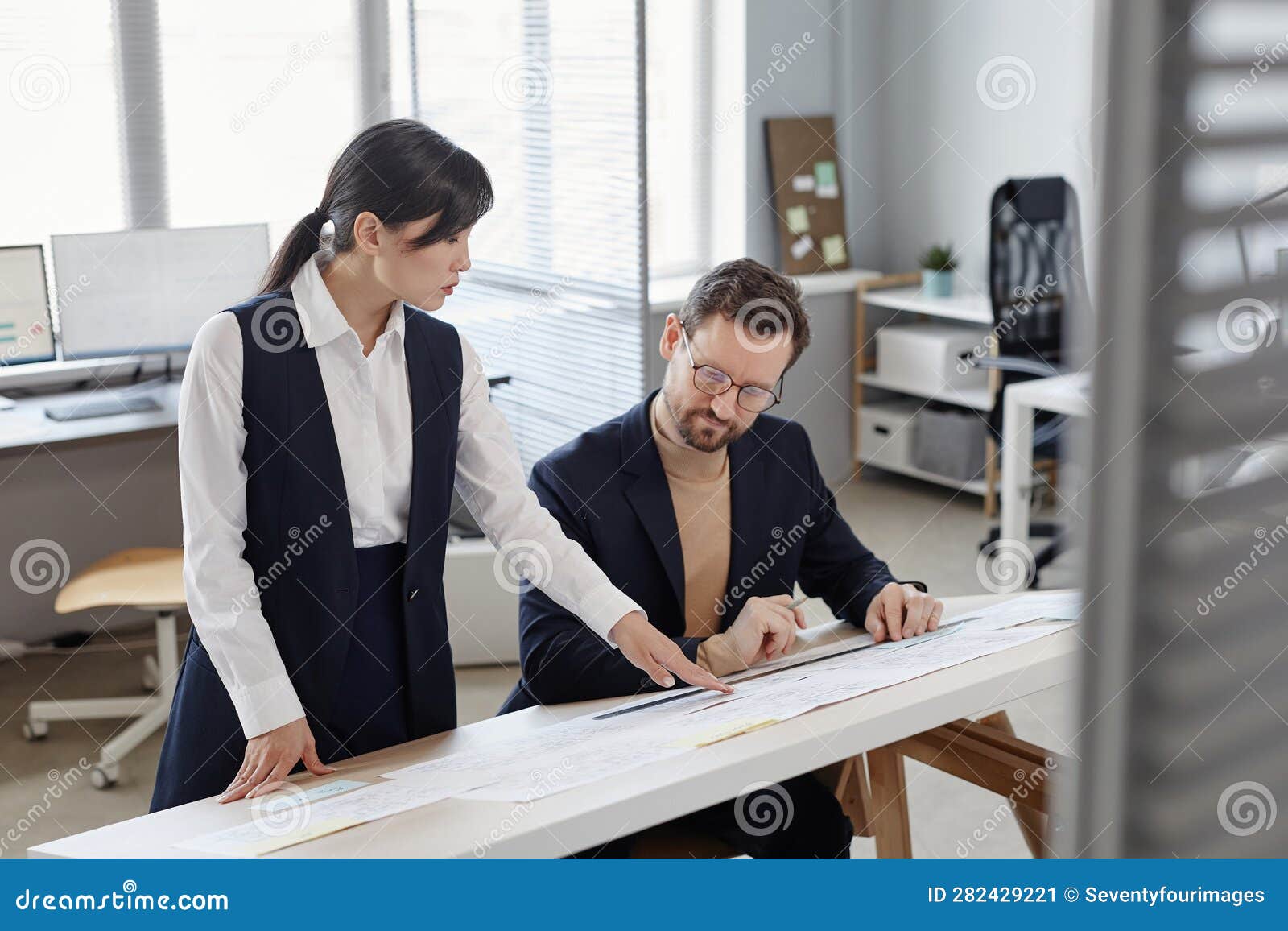 Two Engineers at Workstation Drawing Blueprints and Plans in Office ...