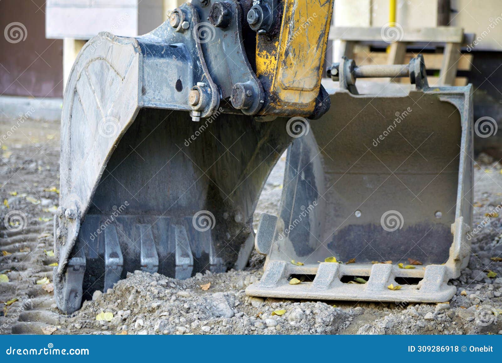 Two Excavator Buckets at the Construction Site of Road Repair Work ...