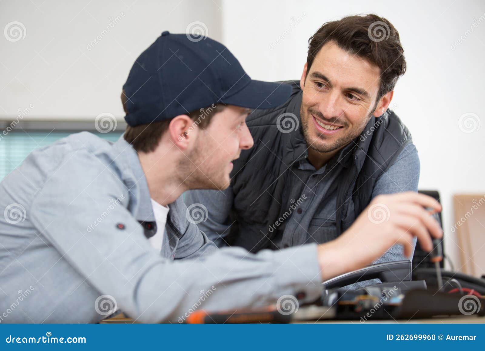 Two Experts Talking at Work Station Stock Photo - Image of headwear ...