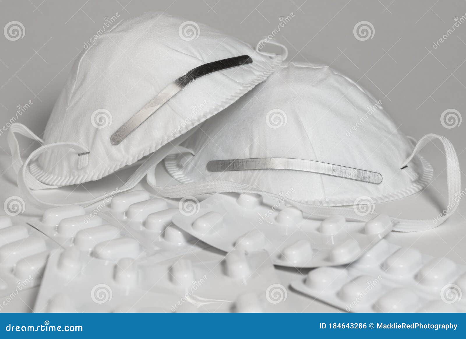 Two Face Masks and Stack of Medicine Packets Isolated on a White ...
