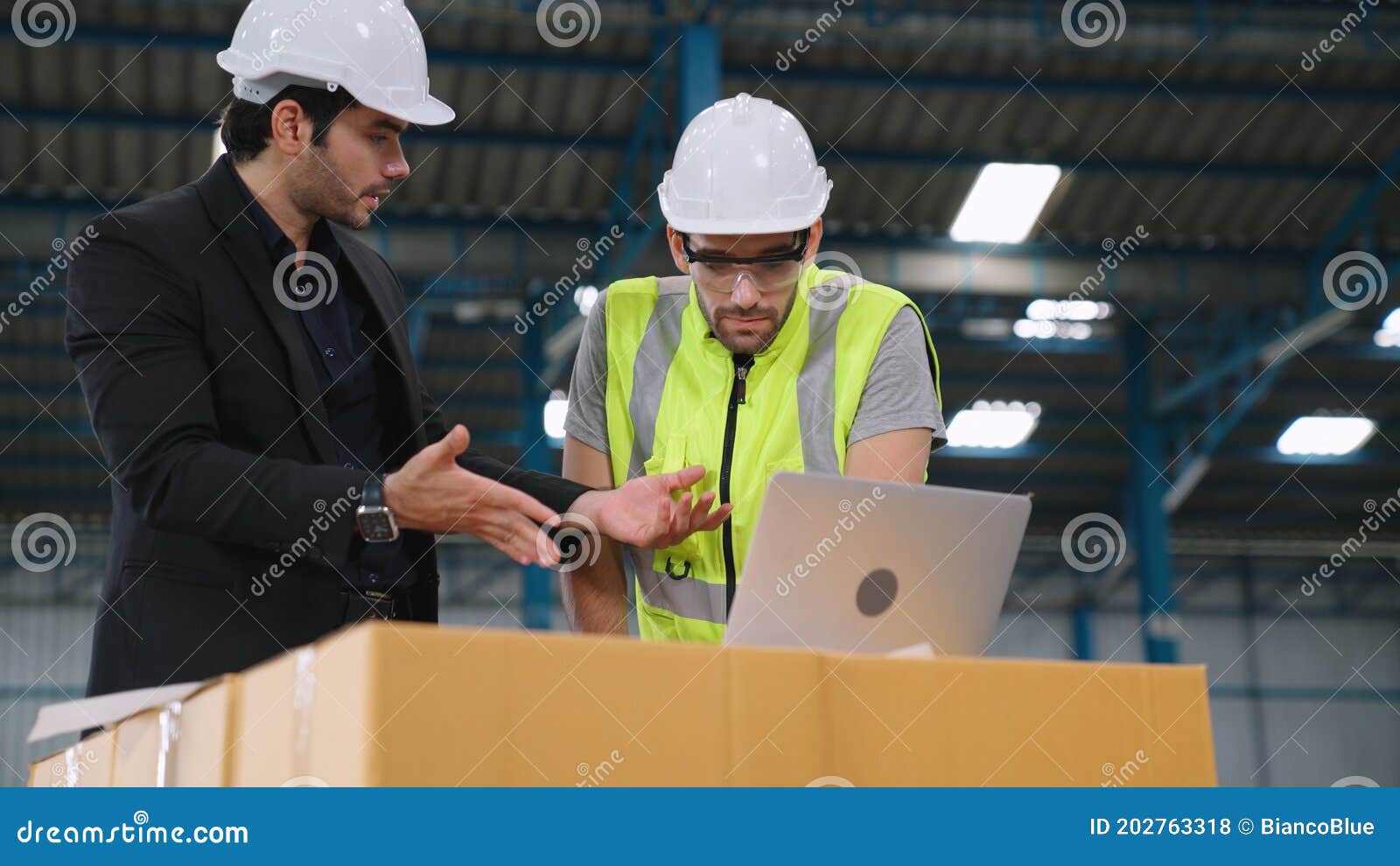 Two Factory Workers Working and Discussing Manufacturing Plan in the ...