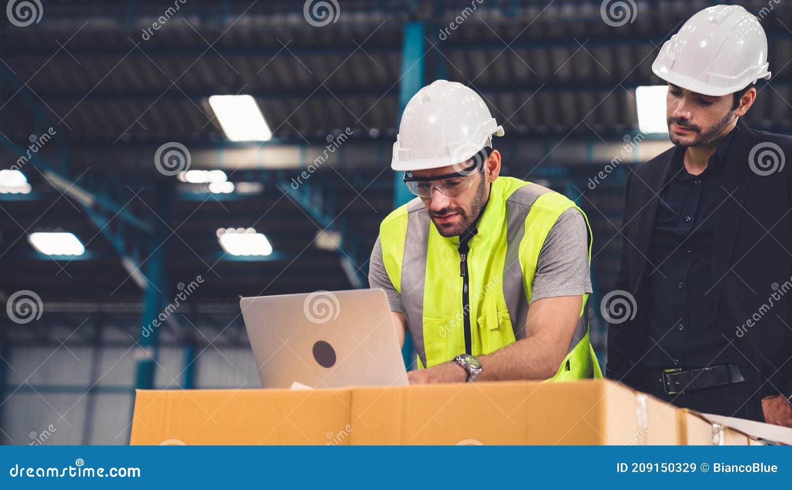 Two Factory Workers Working and Discussing Manufacturing Plan in the ...