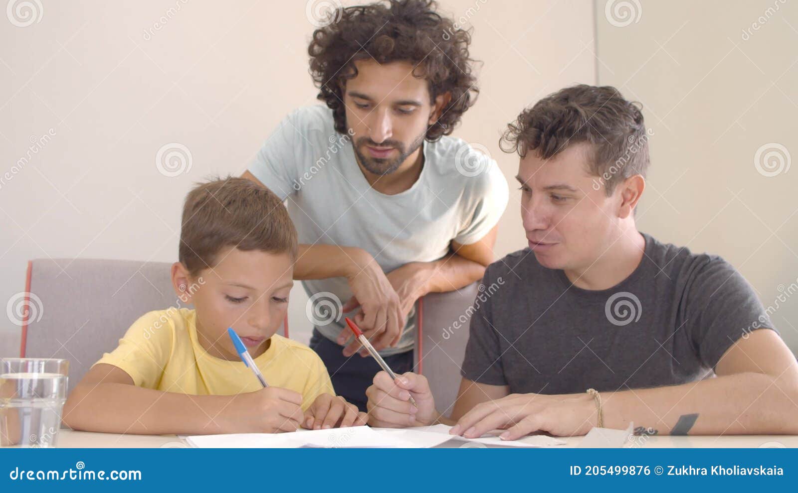 Two Fathers Helping Son with Writing Task Stock Footage - Video of ...