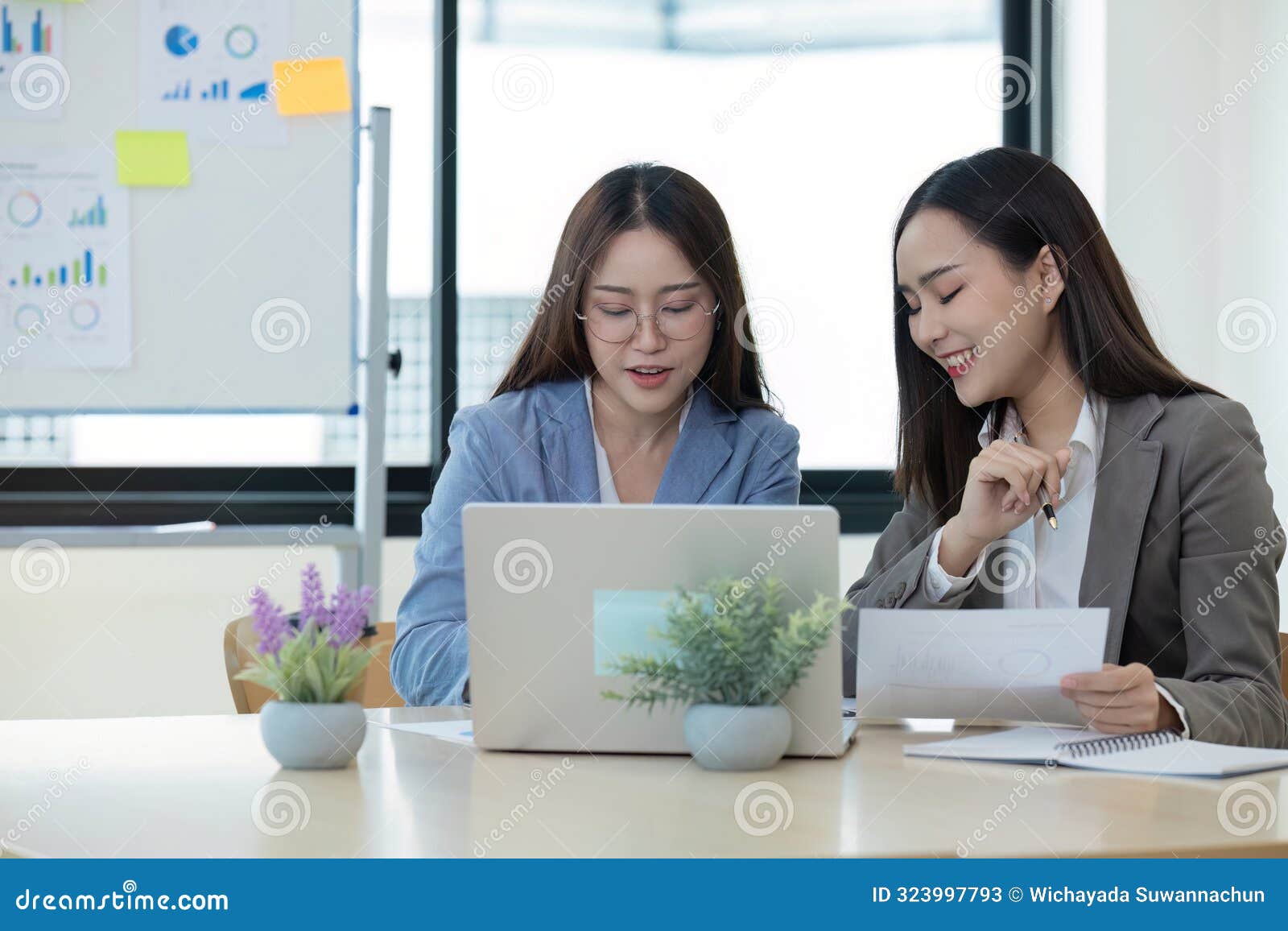 Two Female Accountant Collaborating on Financial Graphs and Data ...