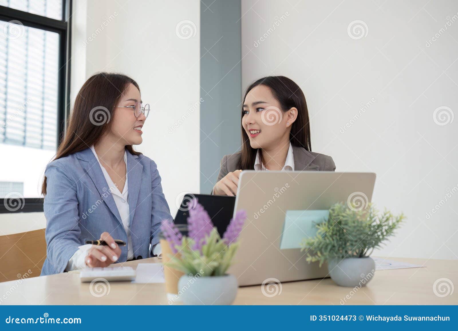 Two Female Accountant Collaborating on Financial Graphs and Data ...