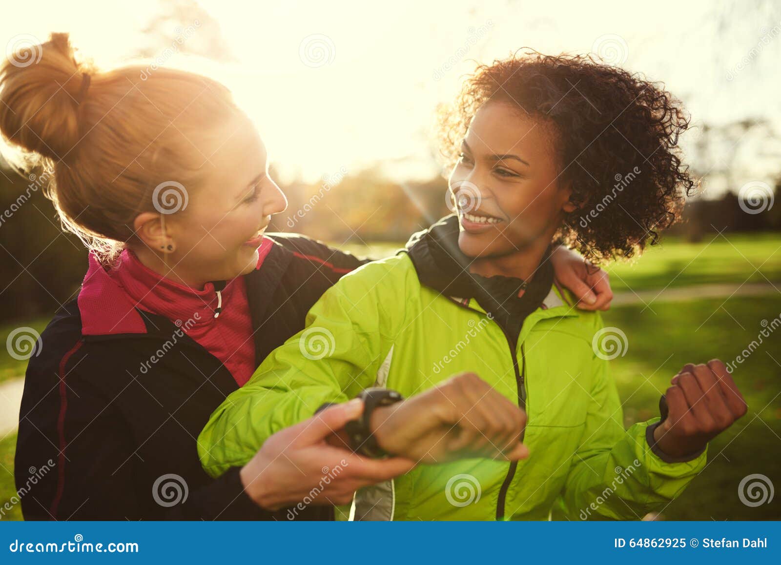 Two Female Athletes Smiling and Hugging after Workout in Park Stock ...