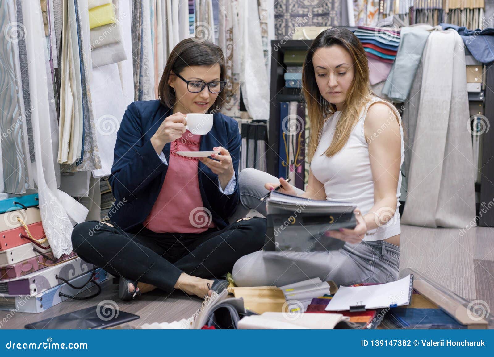 Two Female Decorator, Designer Working with Samples of Fabrics and ...