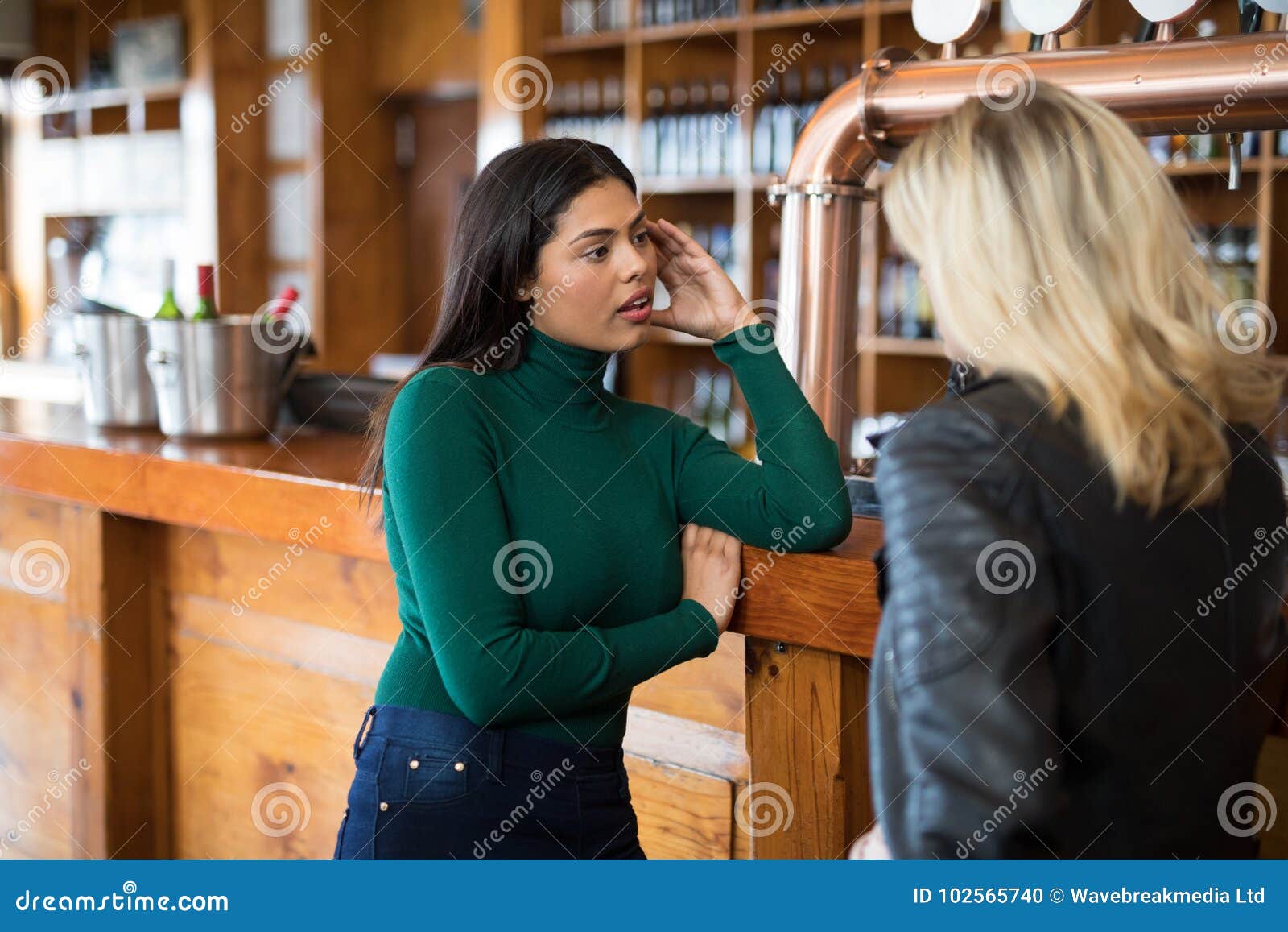 Two Female Friends Interacting with Each Other at Counter Stock Photo ...