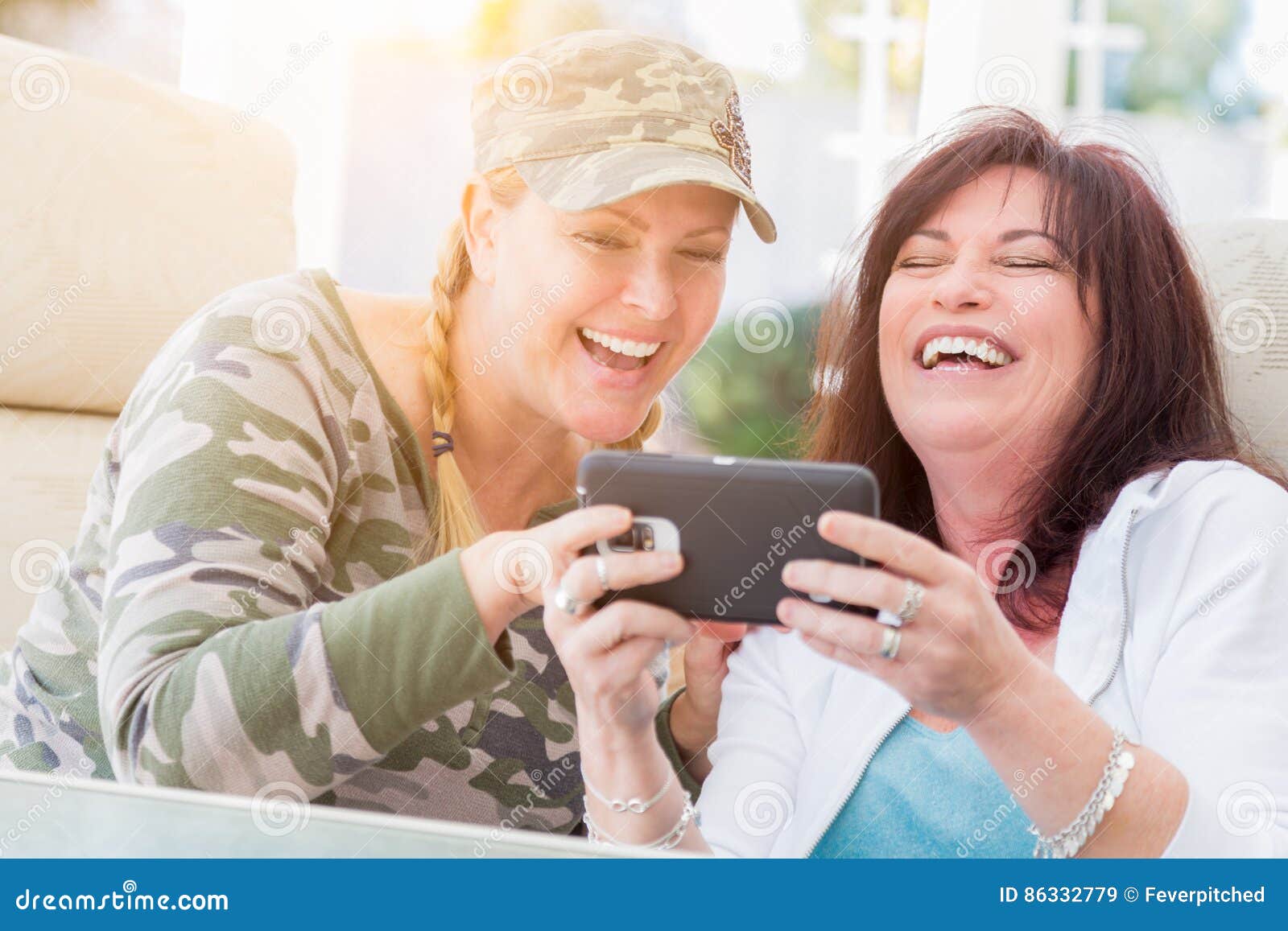 Two Female Friends Laugh while Using a Smart Phone Stock Image - Image ...