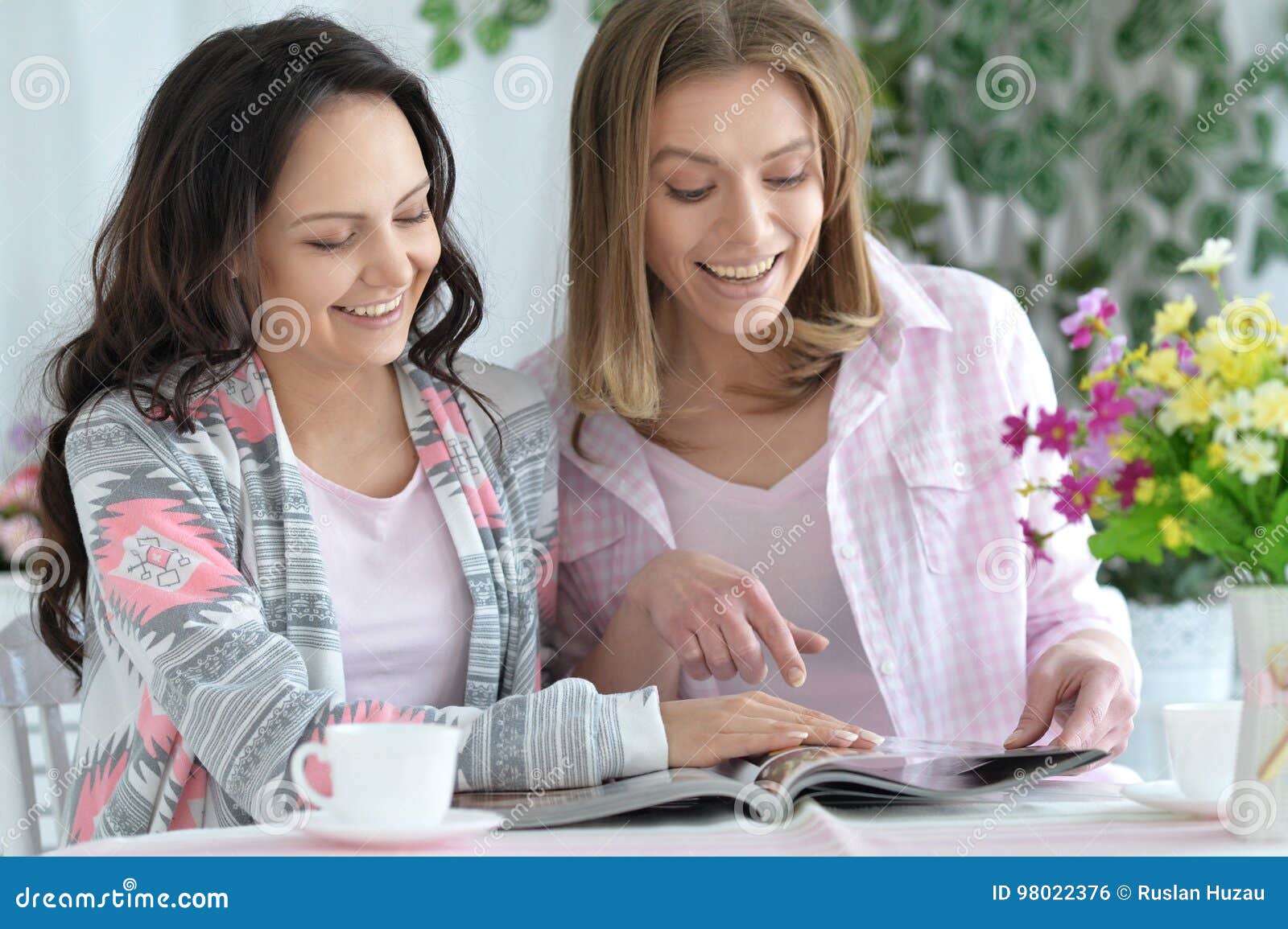 Two Female Friends Reading Magazine Stock Photo - Image of people ...