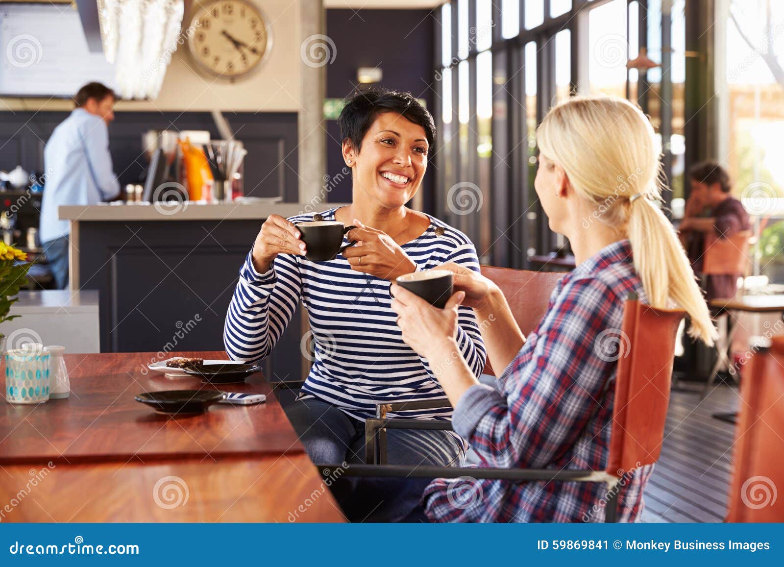 Two Female Friends Talking At A Coffee Shop Stock Photo - Image: 59869841