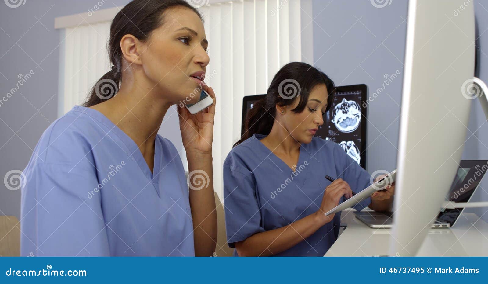 Two Female Medical Personnel Working As a Team Using Modern Technology ...