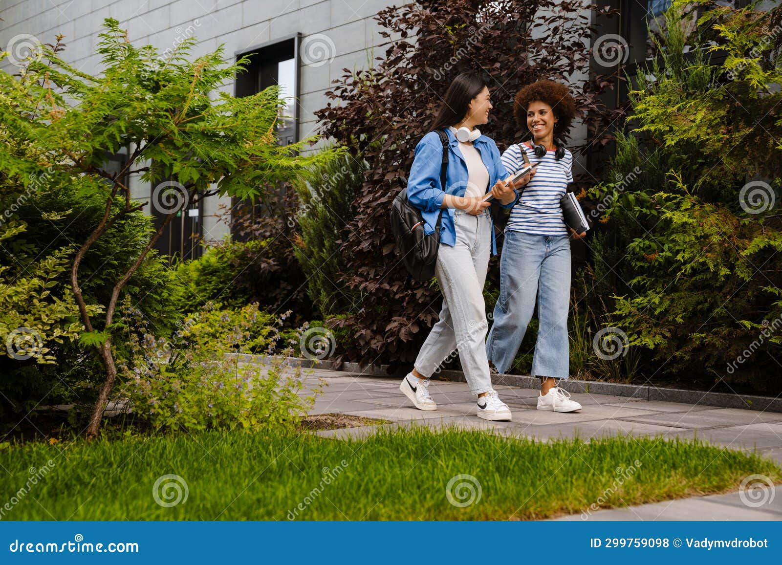 Two Female Students Smiling while Walking in University Campus Stock ...