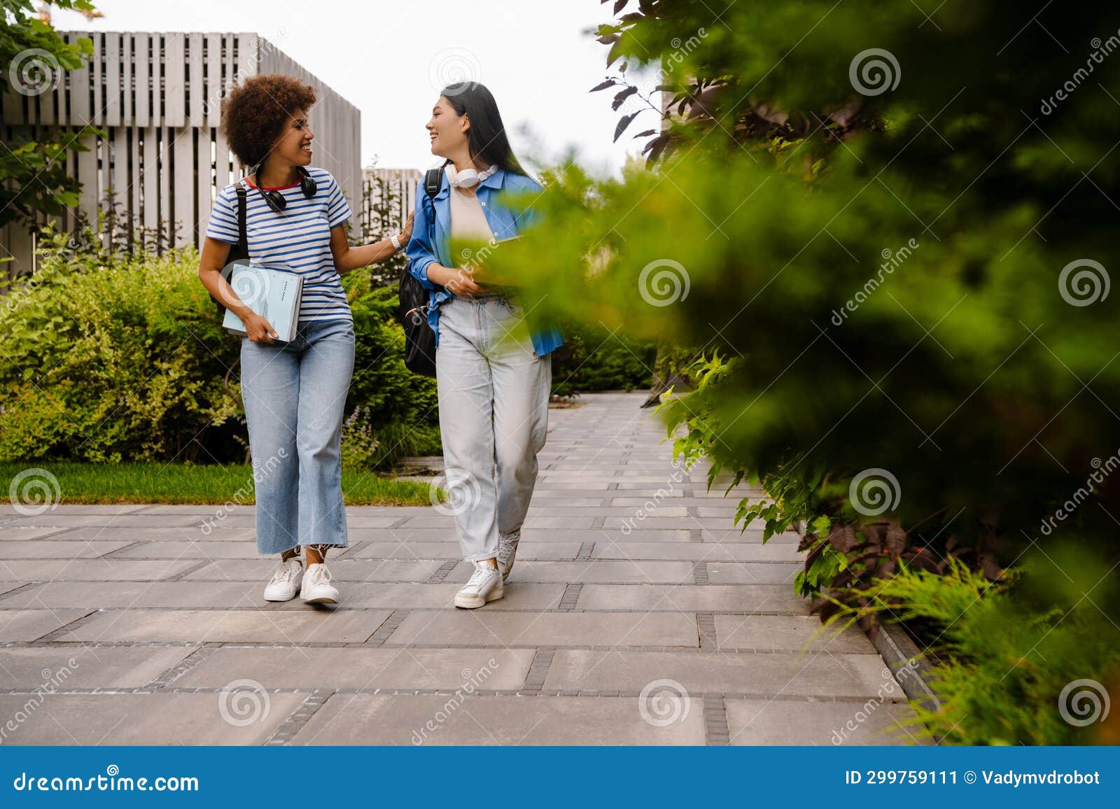 Two Female Students Smiling while Walking in University Campus Stock ...