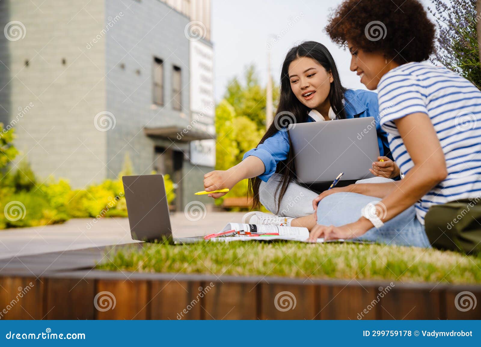 Two Female Students Using Laptops while Studying Together Outdoors in ...