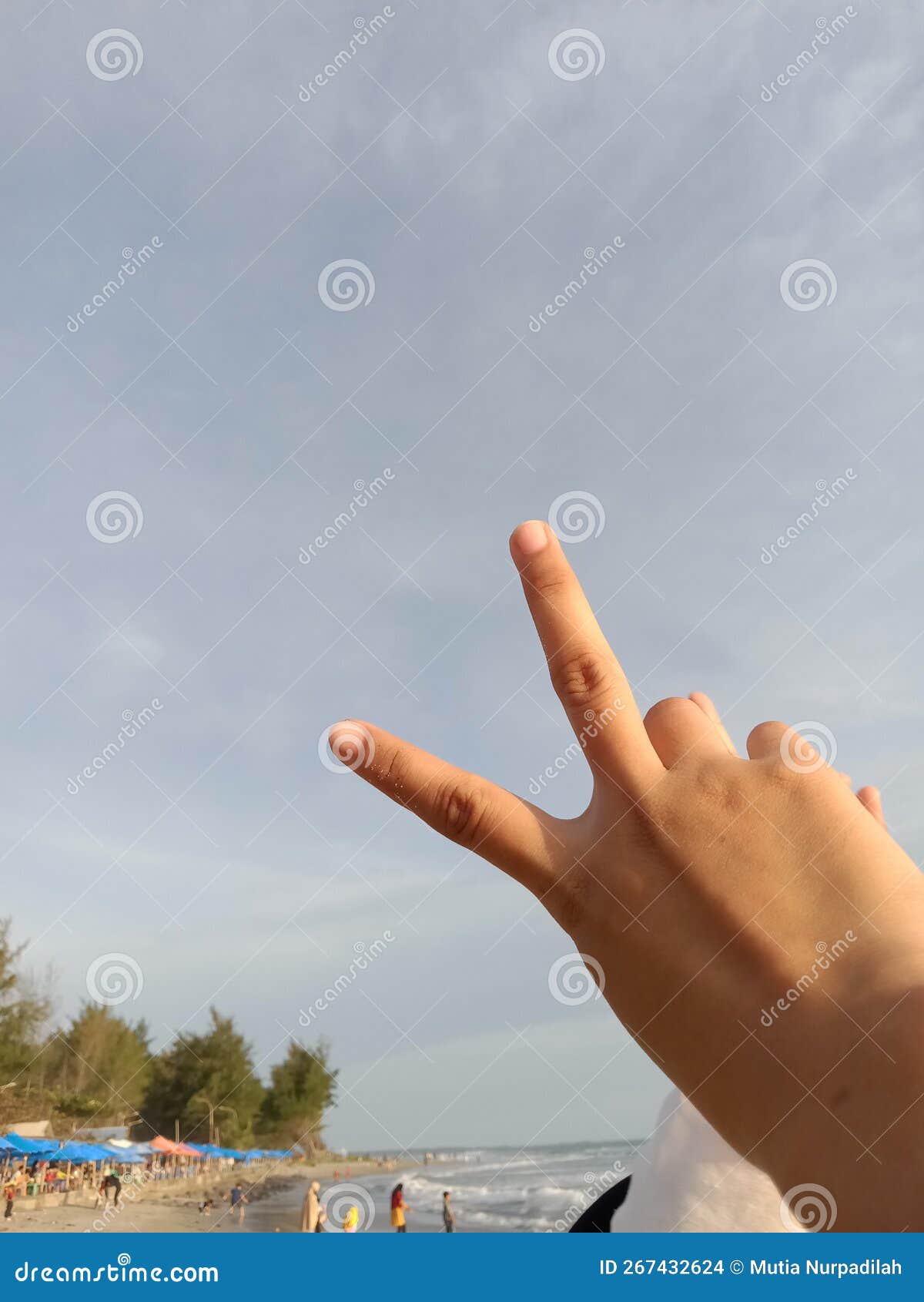 Two-finger Pose on a Crowded Beach Stock Photo - Image of sand, blue: 267432624