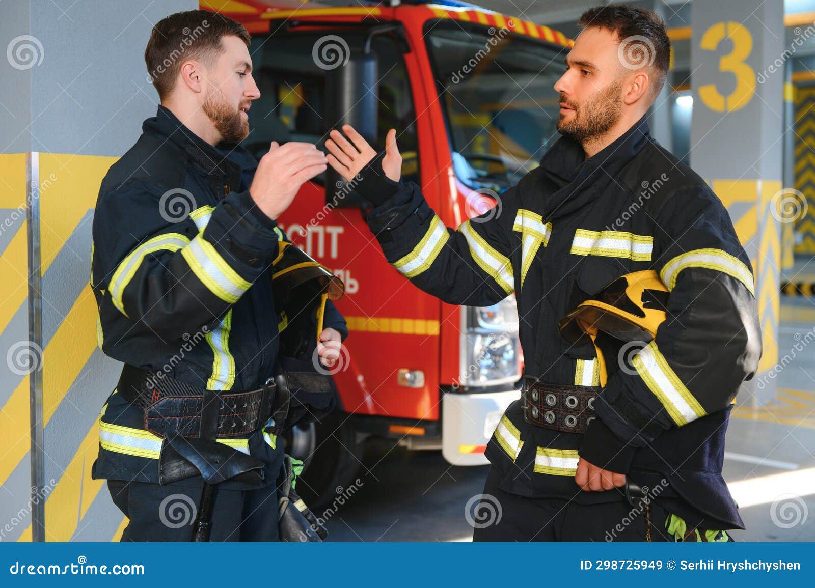 Two Firefighters in Protective Clothing in Helmets with Fire Engine ...