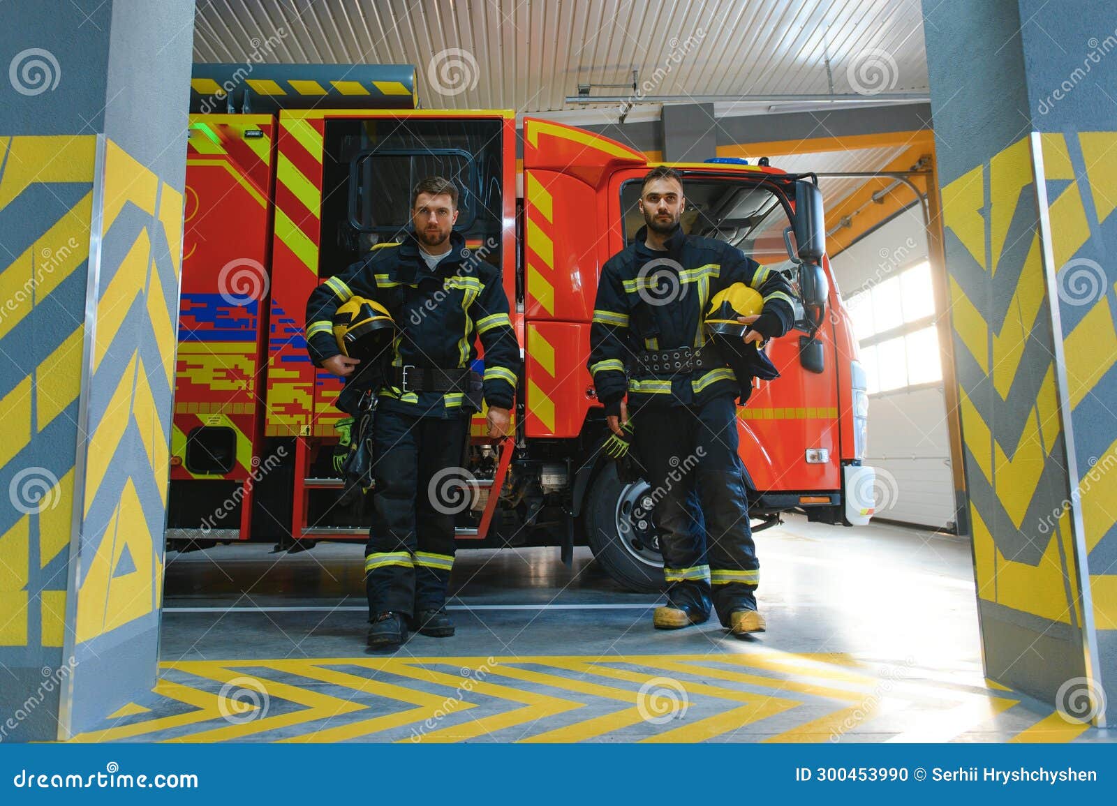 Two Firefighters in Protective Clothing in Helmets with Fire Engine ...