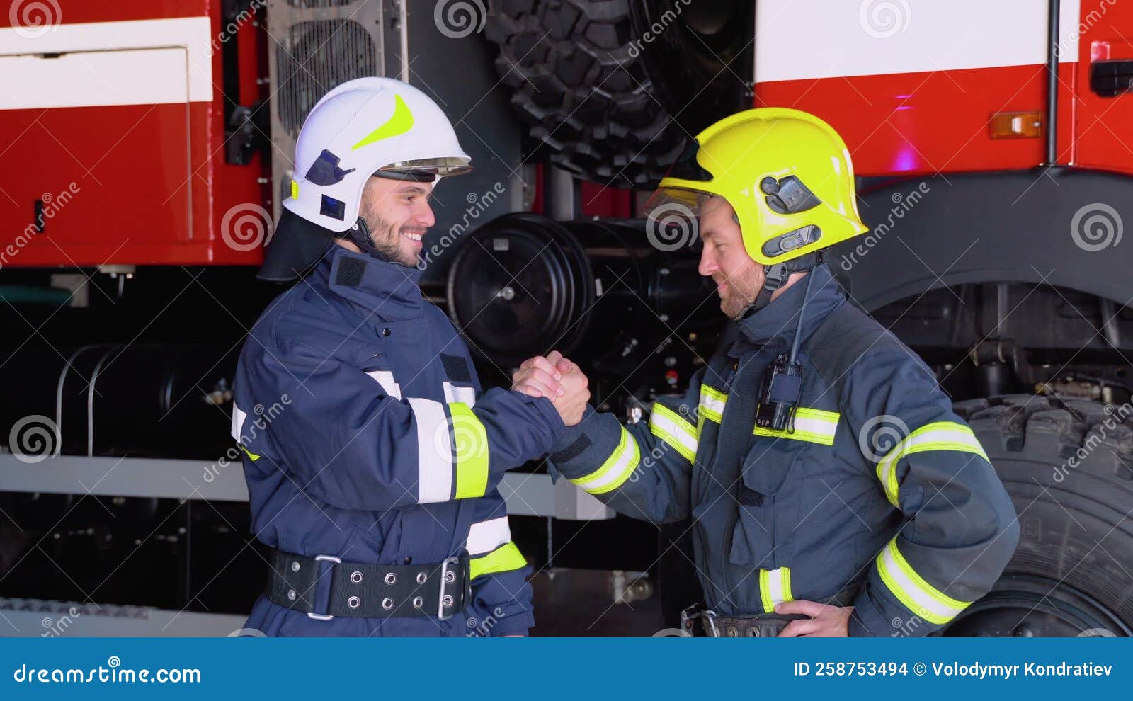 Two Firefighters in Protective Clothing in Helmets with Fire Engine ...