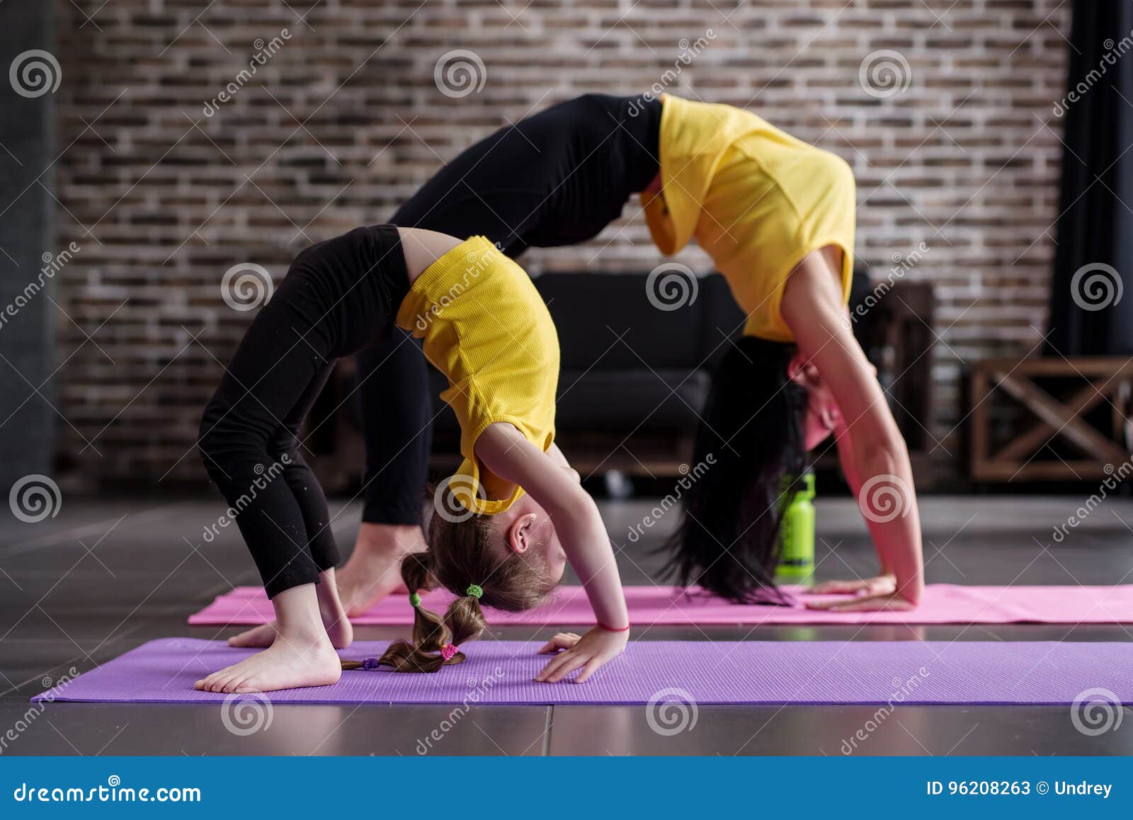 Two Flexible Girls Gymnasts With Pigtails, In Beige Leotards Are ...