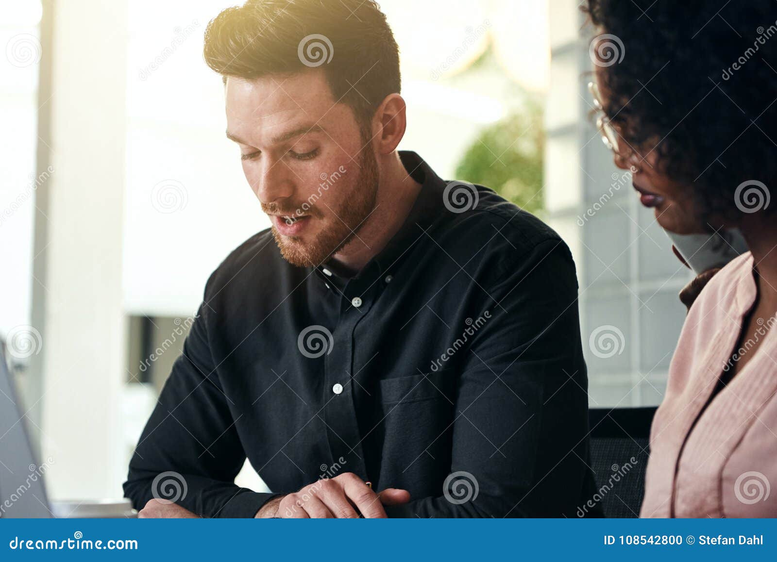 Two Focused Businesspeople Talking Together at an Office Desk Stock ... Two Focused Businesspeople Talking Together at an Office Desk Stock ...