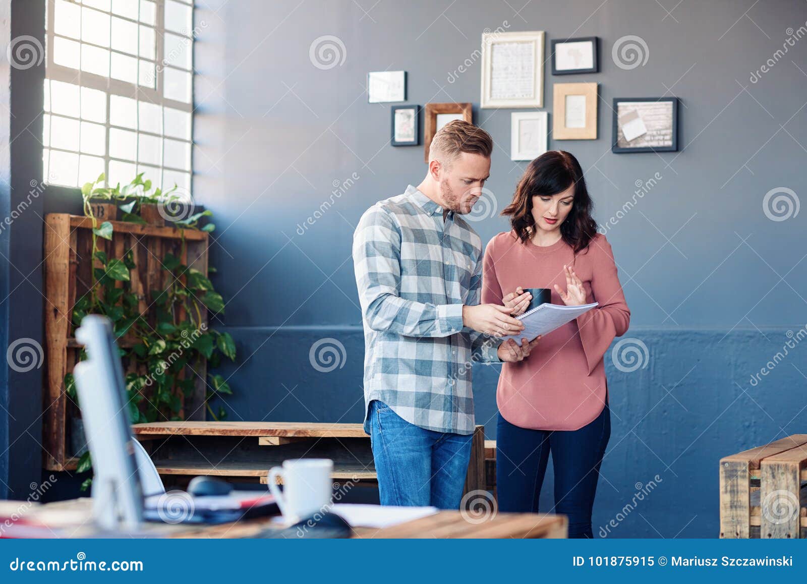 Two Focused Work Colleagues Discussing Paperwork Together in an Office ...