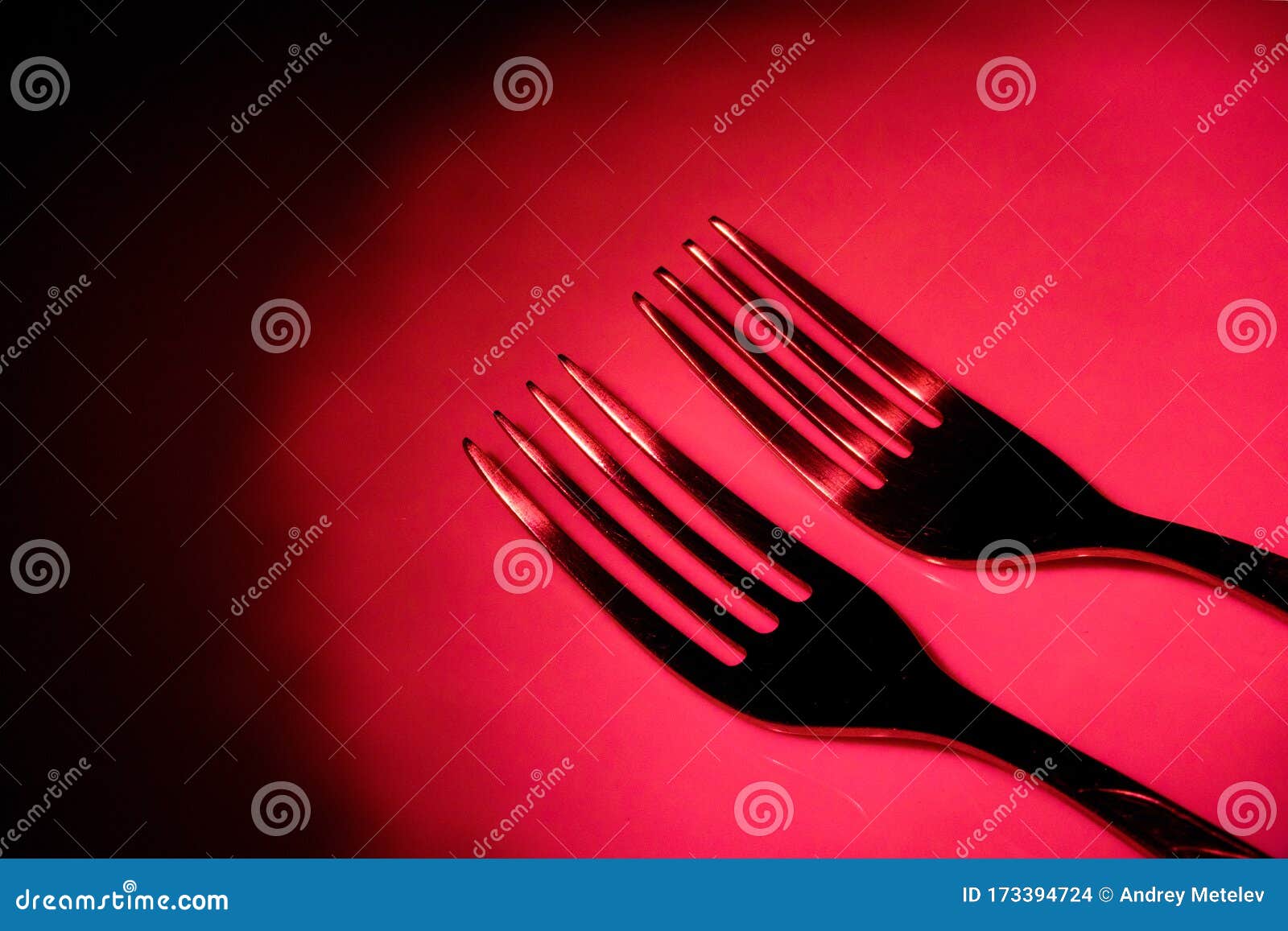 Two Forks on a Ceramic Plate in a Red Circle of Light Stock Photo ...