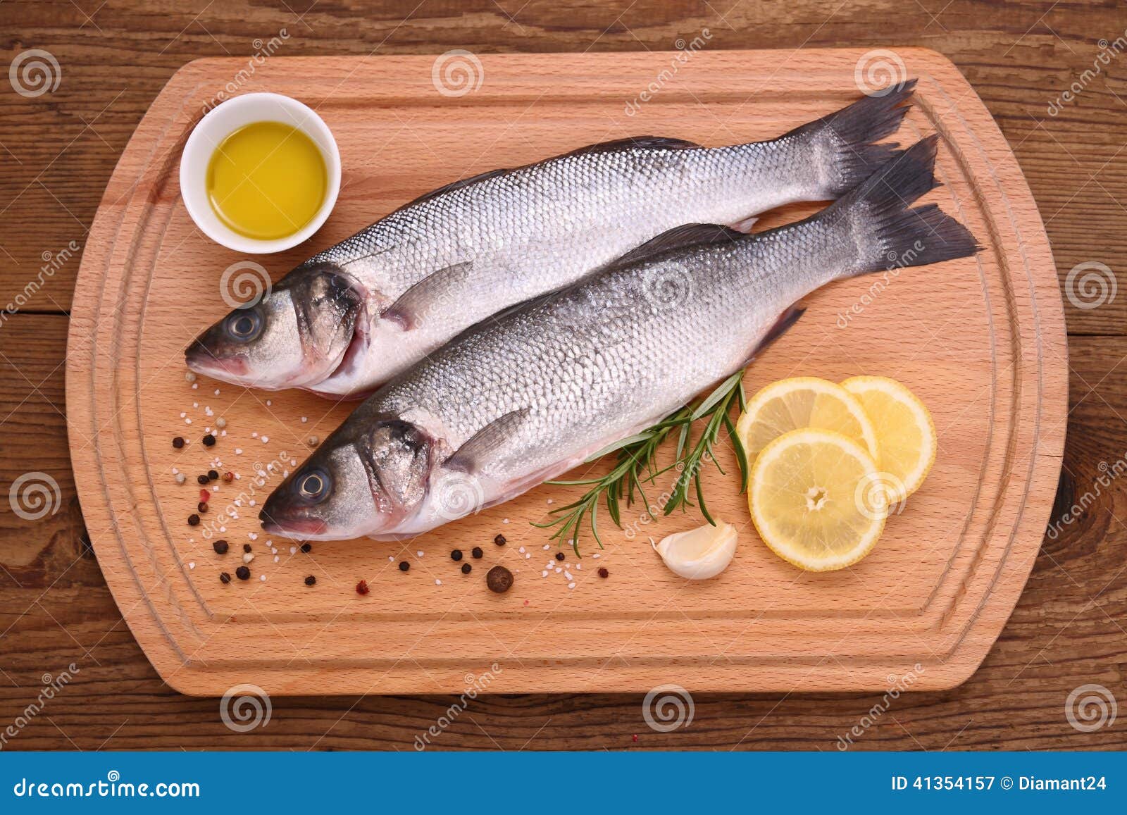 Two Fresh Moronidae Fish on Cutting Board with Ingredients Stock Image ...