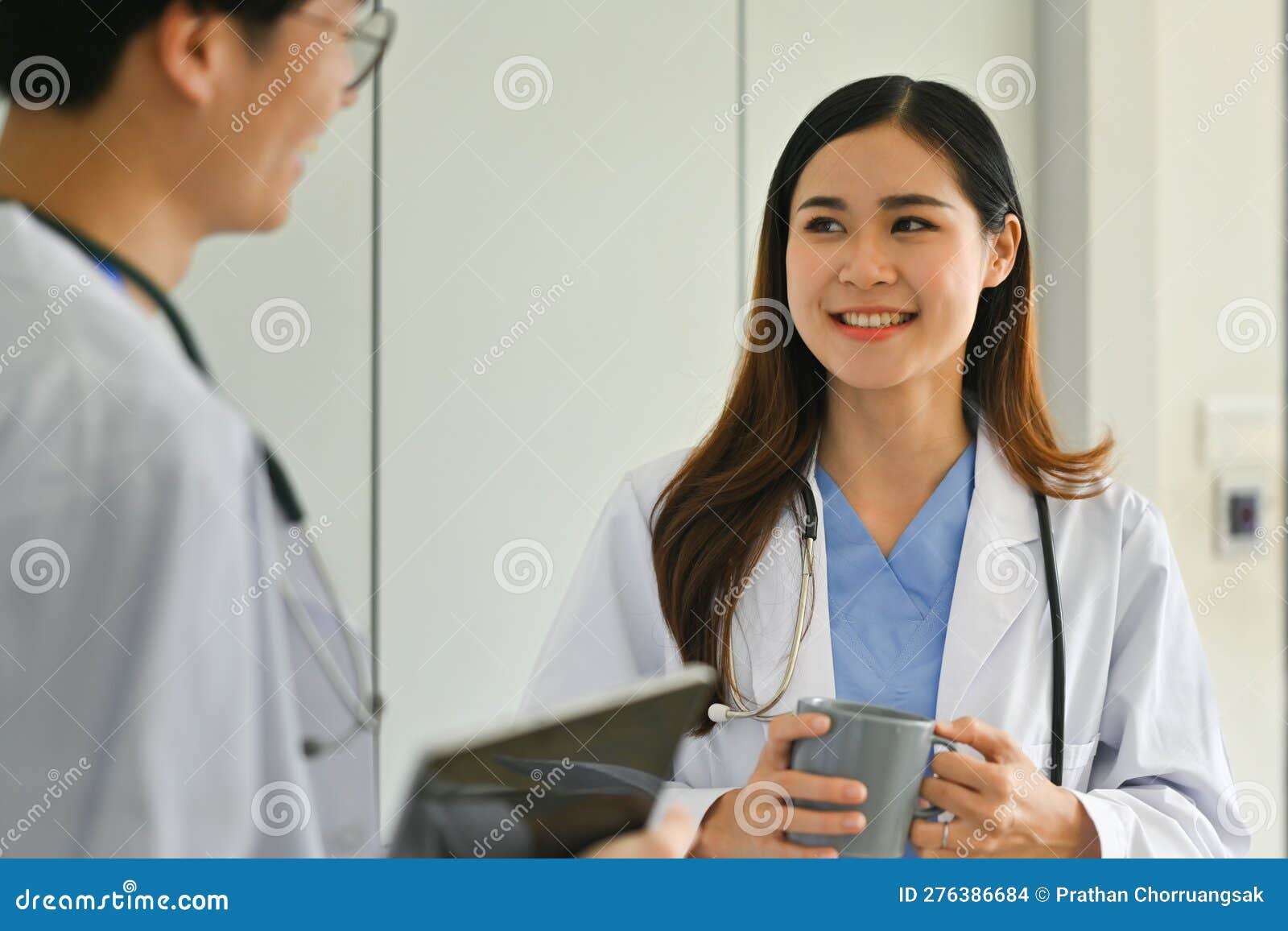 Two Friendly Colleagues Interns in White Uniform Talking and Using ...