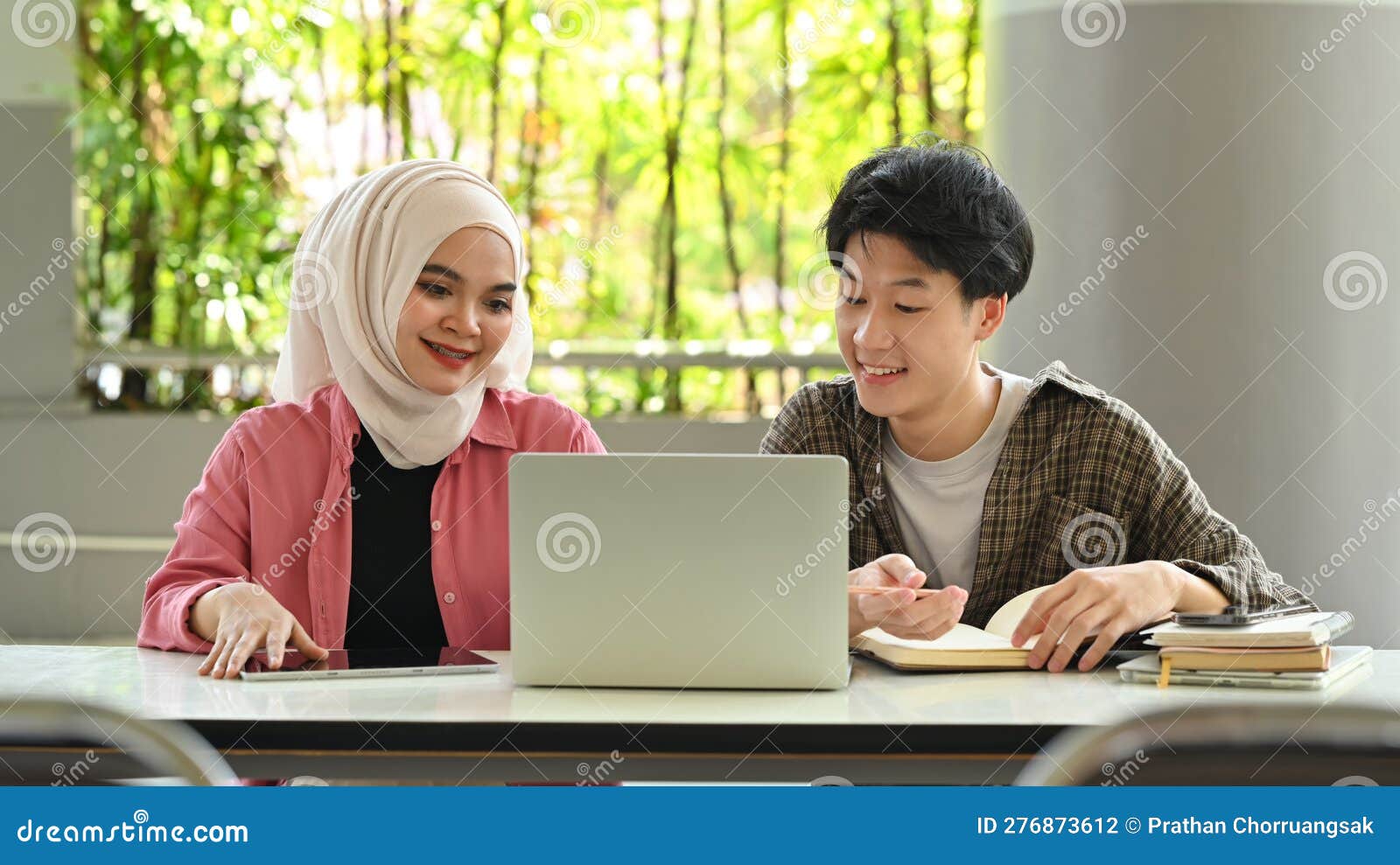 Two Friendly University Student Sitting at Table with Laptop, Talking ...