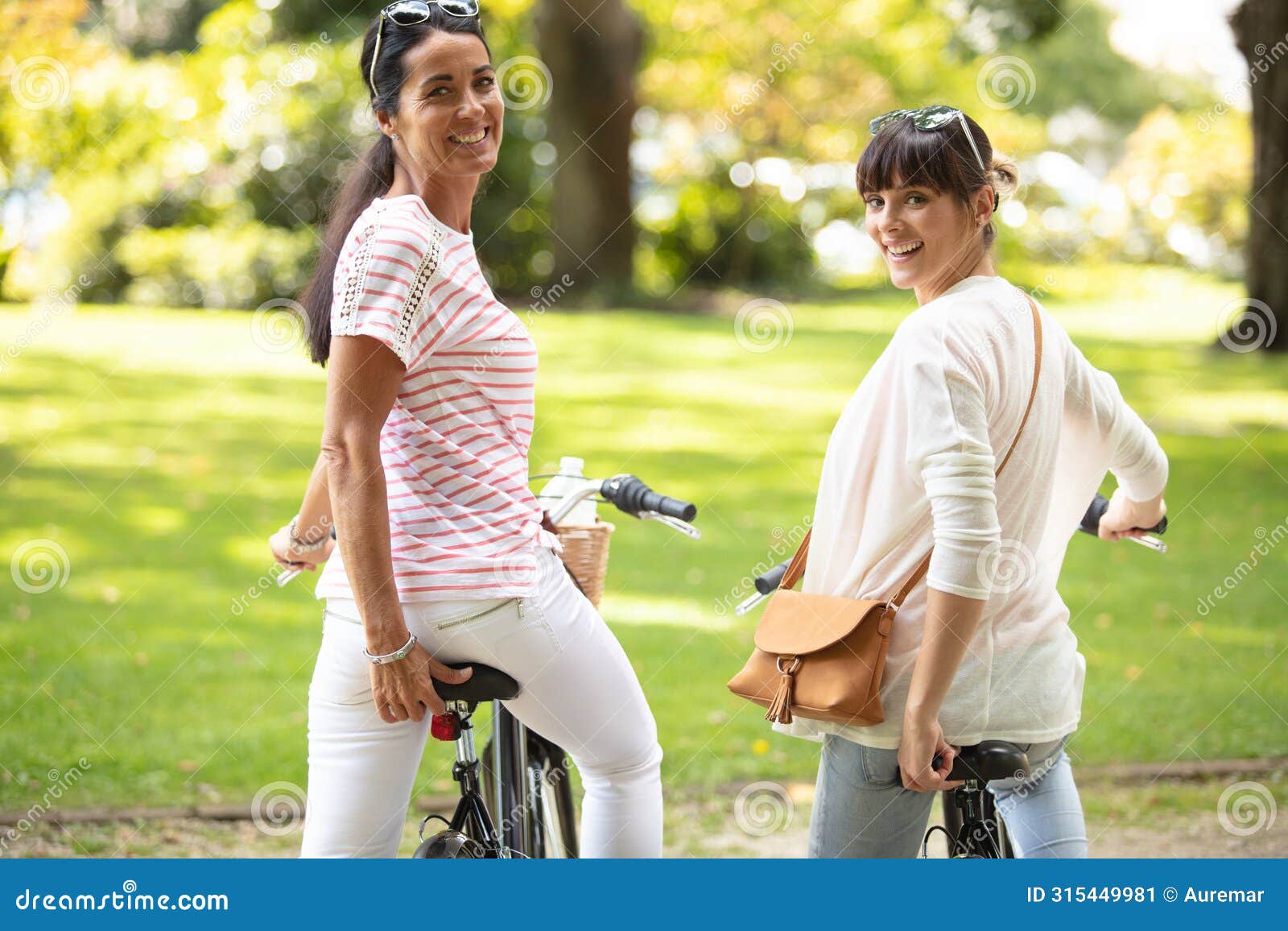 Two Friends on Bikes Looking Back Smiling Stock Image - Image of phone ...