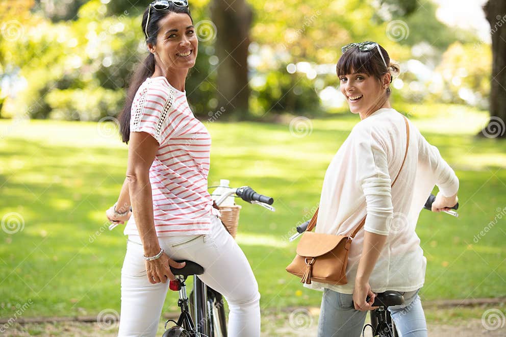 Two Friends on Bikes Looking Back Smiling Stock Image - Image of phone ...