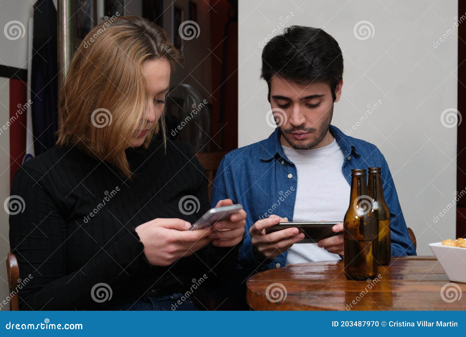 Two Friends Checking Something on Their Smartphone in a Pub Stock Photo ...