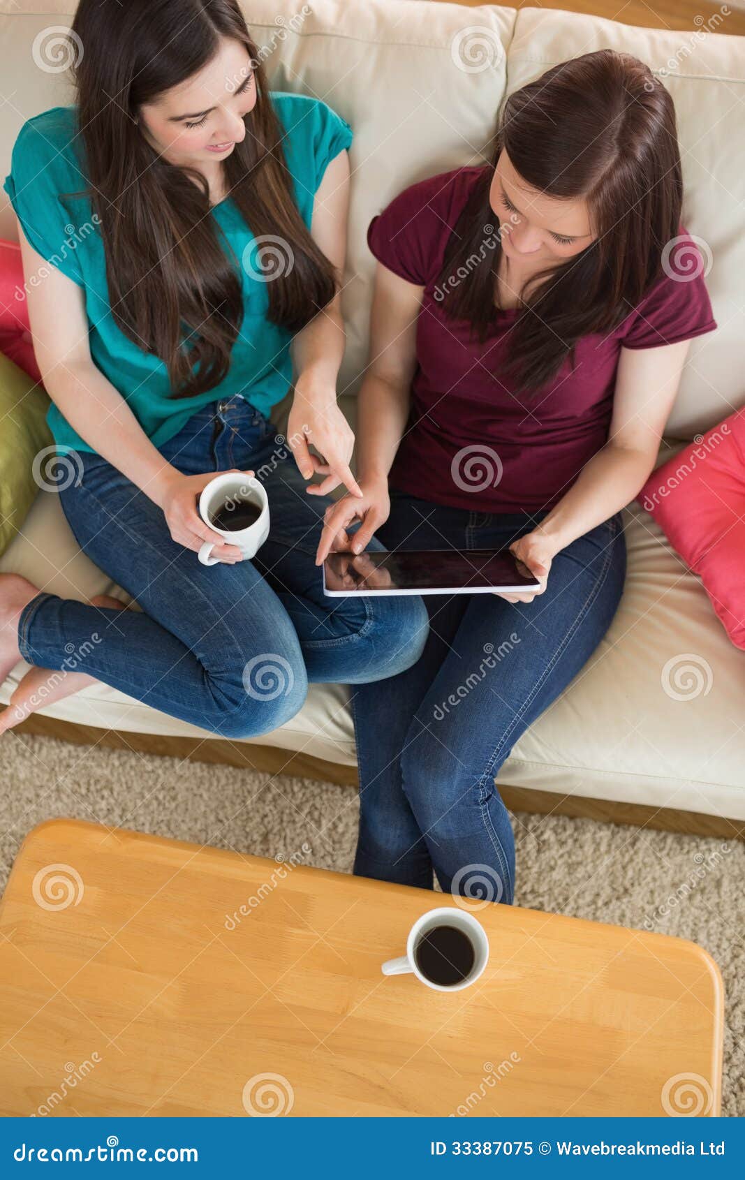 Two Friends Having Coffee on the Couch and Using Tablet Stock Image ...