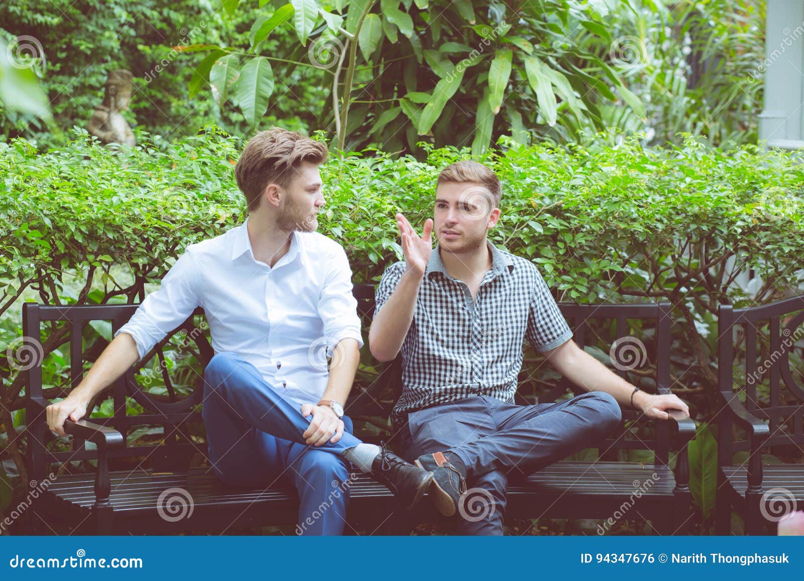 Two Friends Men Talking Sitting in a Garden. Stock Photo - Image of ...
