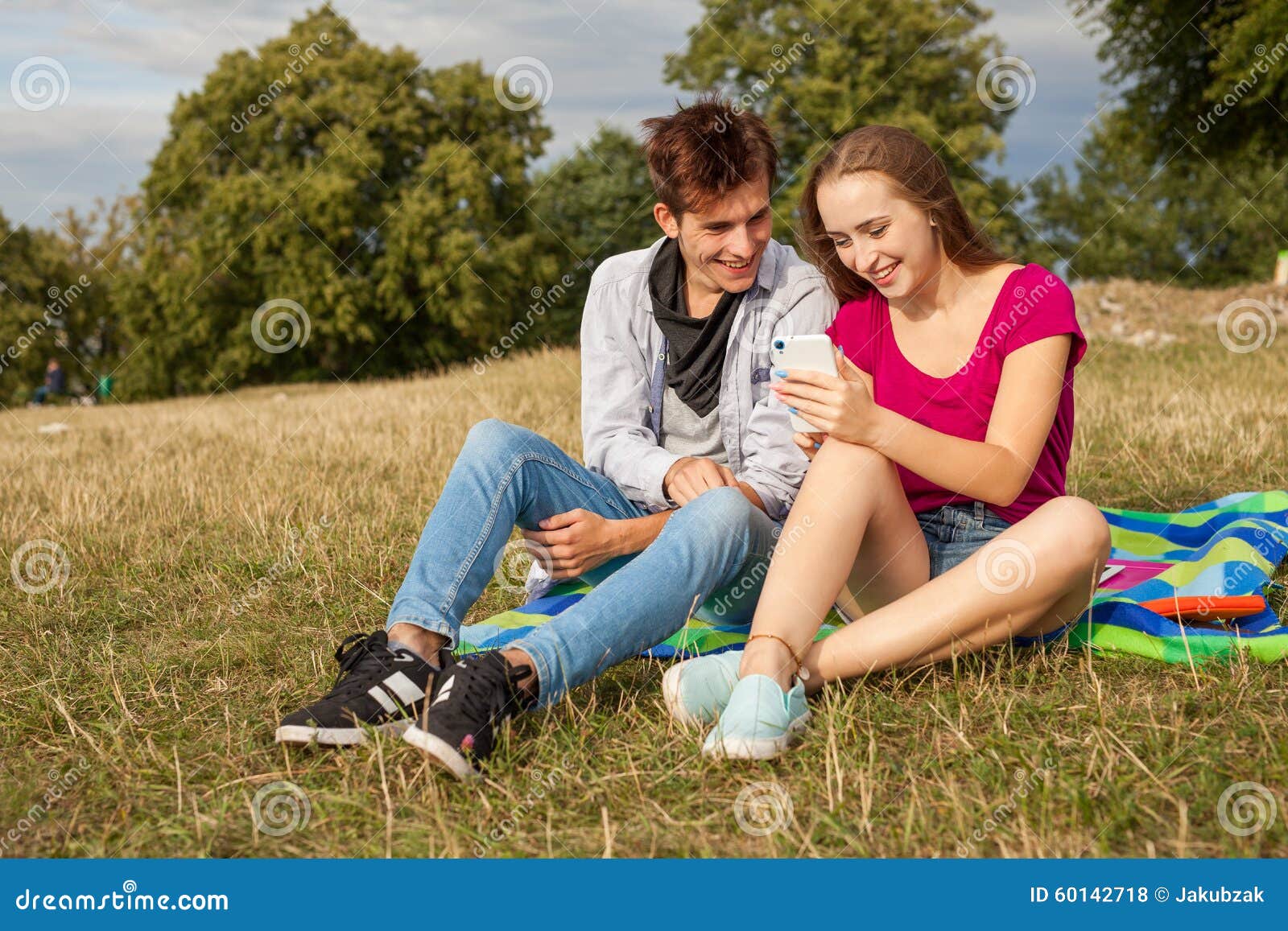 Two Friends in a Park with Mobile Phone. Summer Time. Stock Photo ...