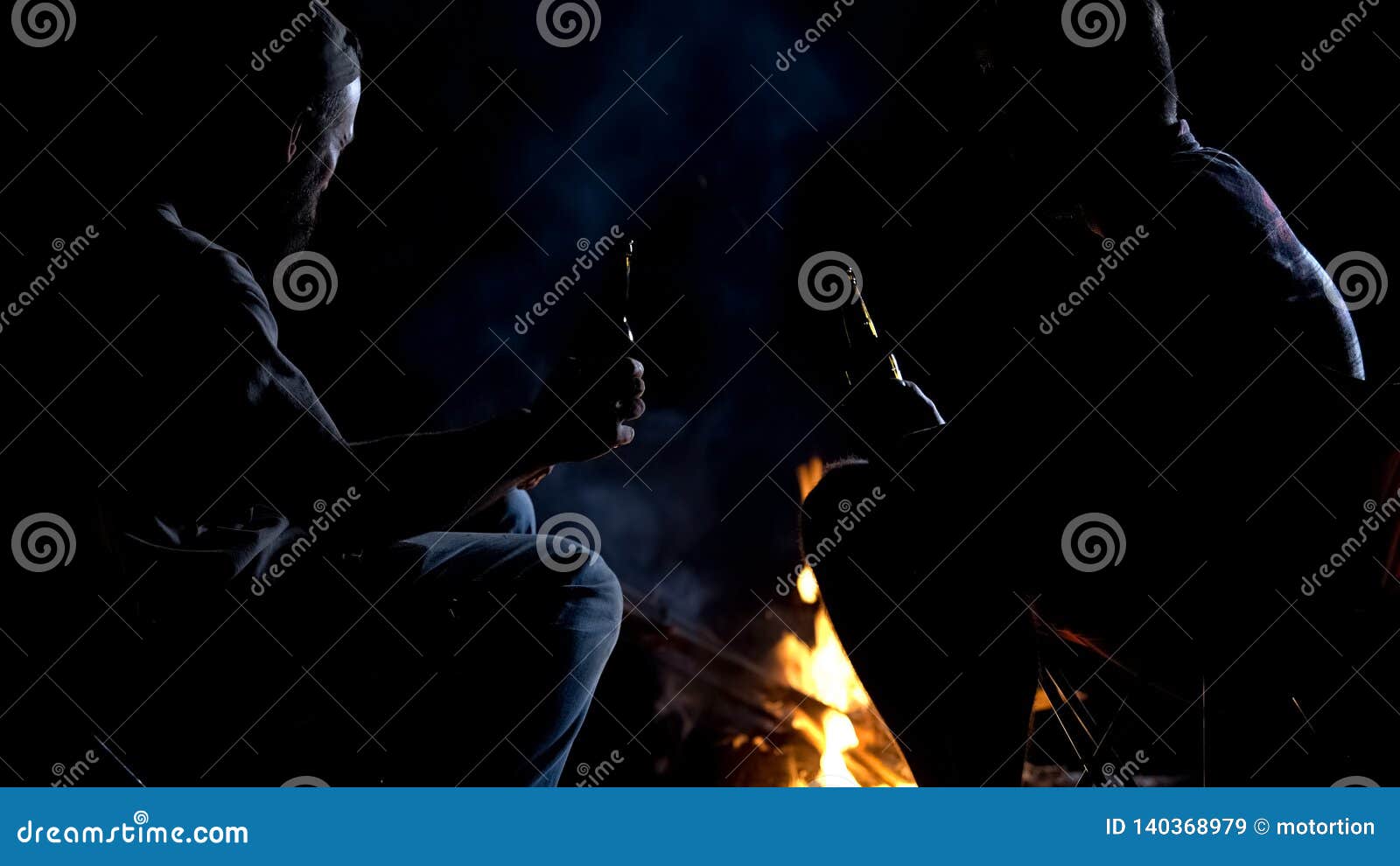 Two Friends Sitting Around Open Fire at Night and Drinking Beer ... Two Friends Sitting Around Open Fire at Night and Drinking Beer ...