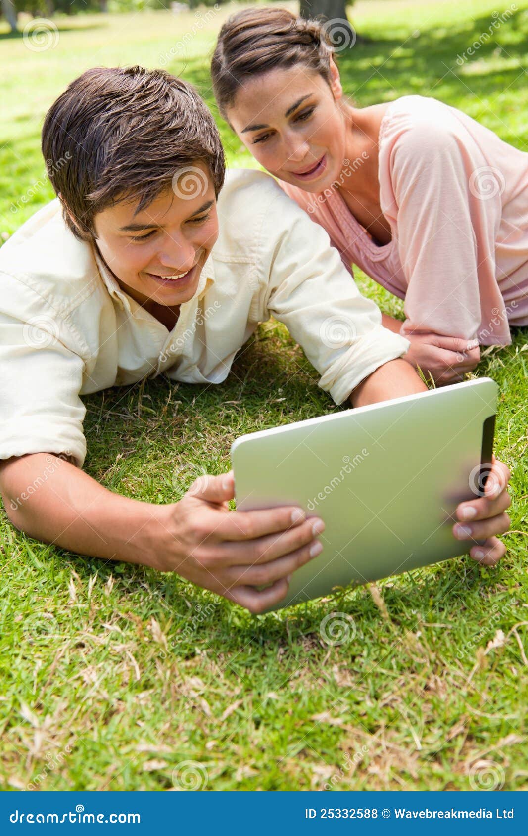 Two Friends Smiling As they Watch Something on a Tablet Together Stock ...