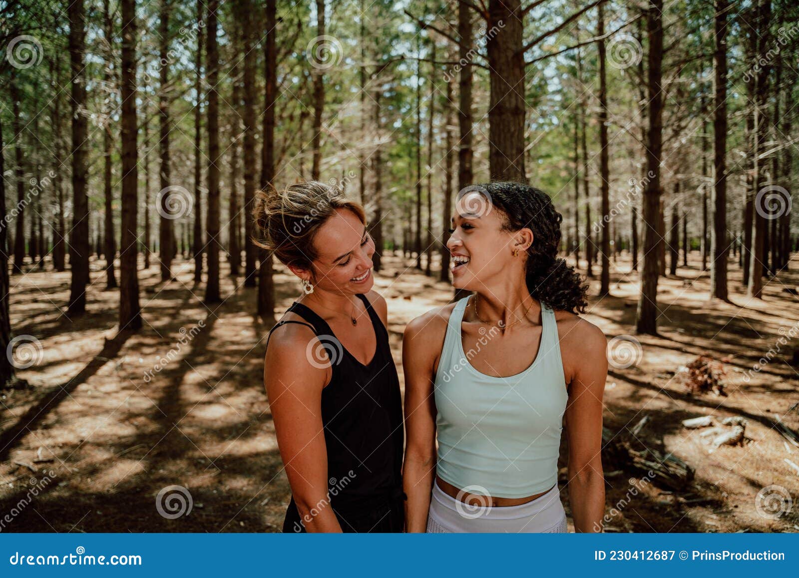 Two Friends Smiling at Each Other Standing in Forest Setting Stock ...