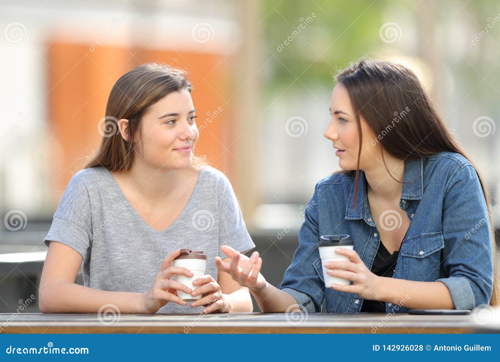 Two Friends Talking in a Park Drinking Coffee Stock Photo - Image of ...